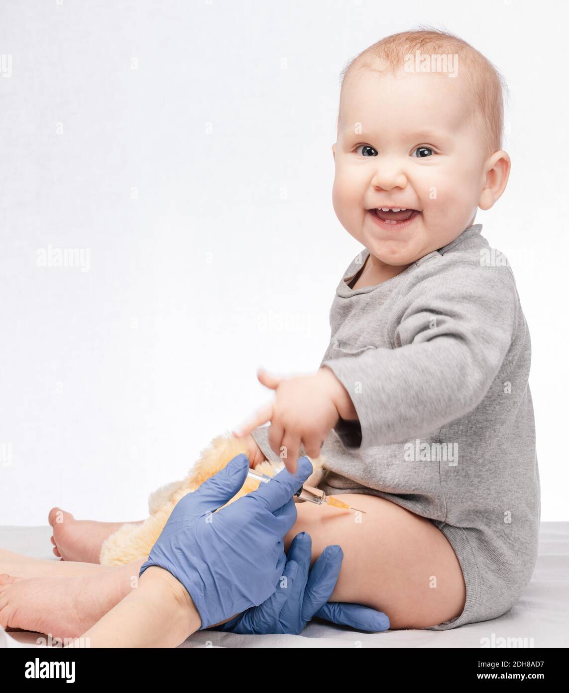 Pediatrician or nurse giving an intramuscular injection of a vaccine to ...