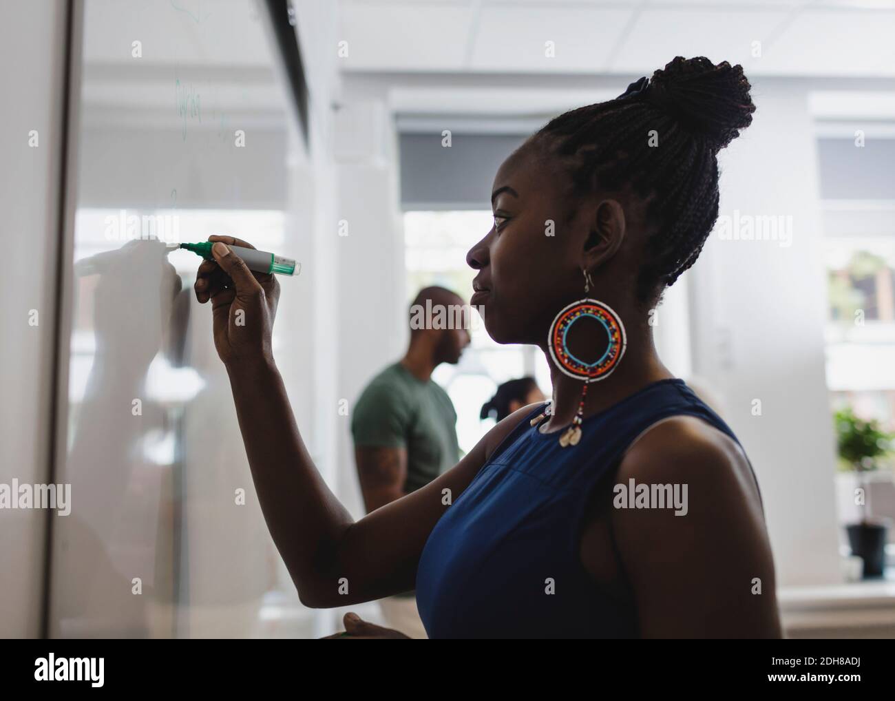 Side view of student writing on whiteboard in language class Stock ...
