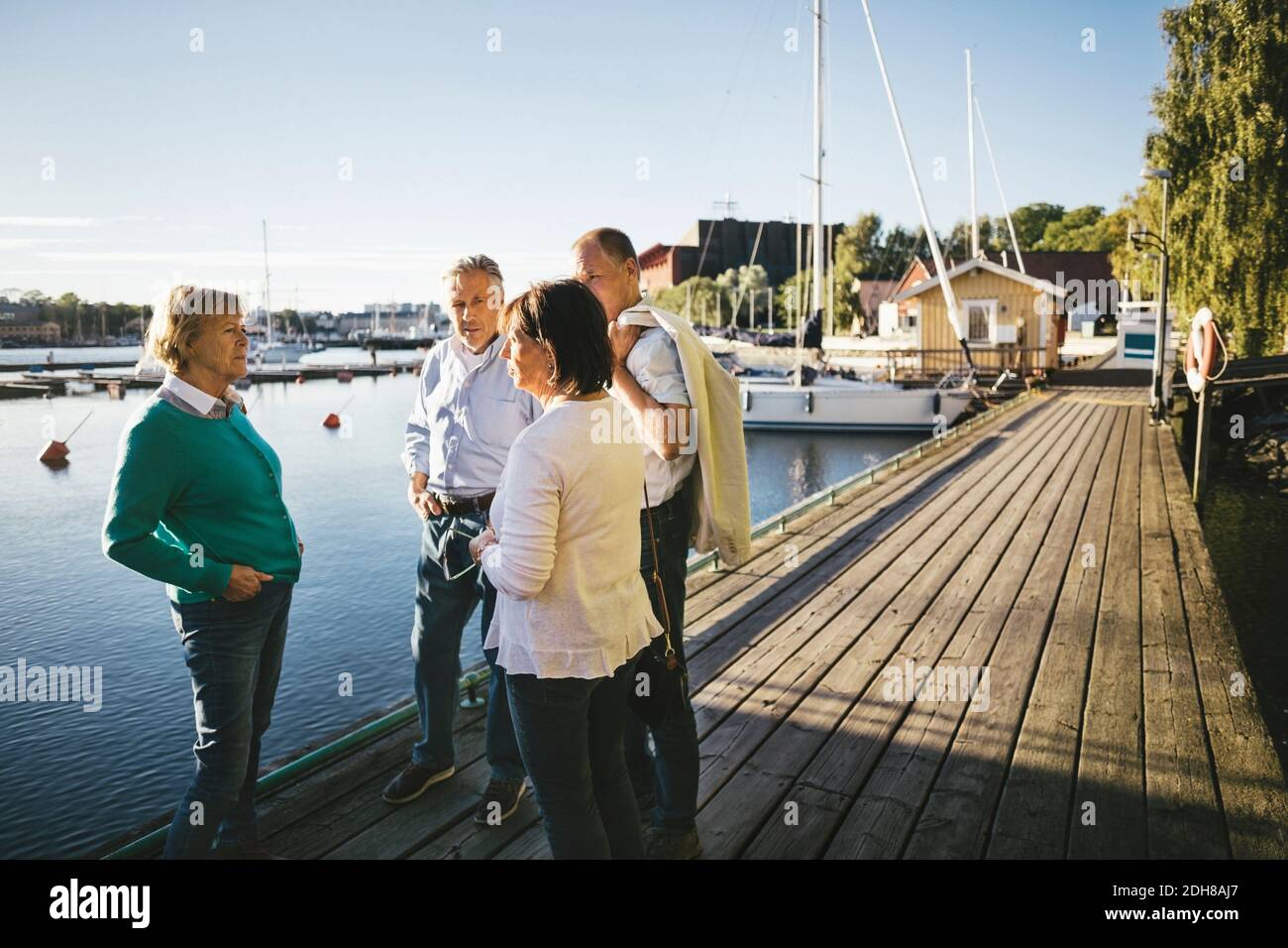 Two senior couples talking while standing on pier Stock Photo - Alamy