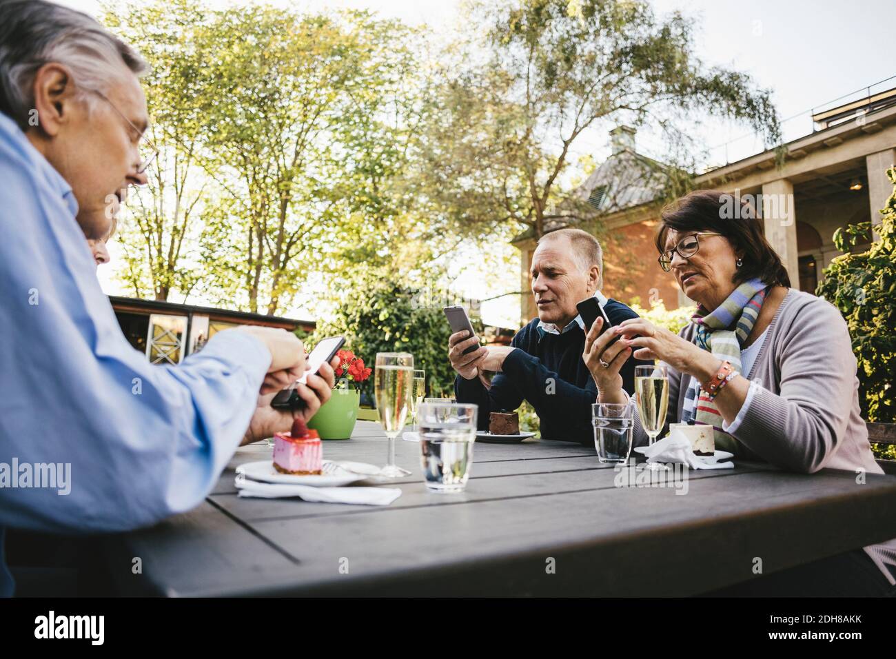 Senior people using mobile phones at table of outdoor restaurant Stock ...
