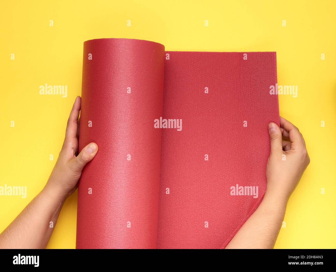 Two female hands unfold a red yoga mat Stock Photo - Alamy