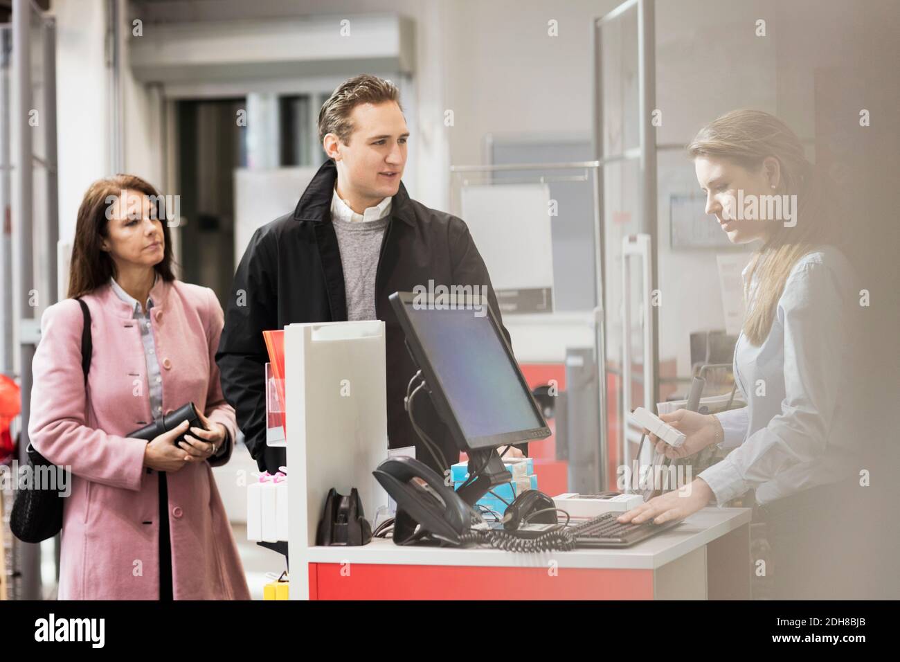 Customers standing at cash counter in showroom Stock Photo - Alamy