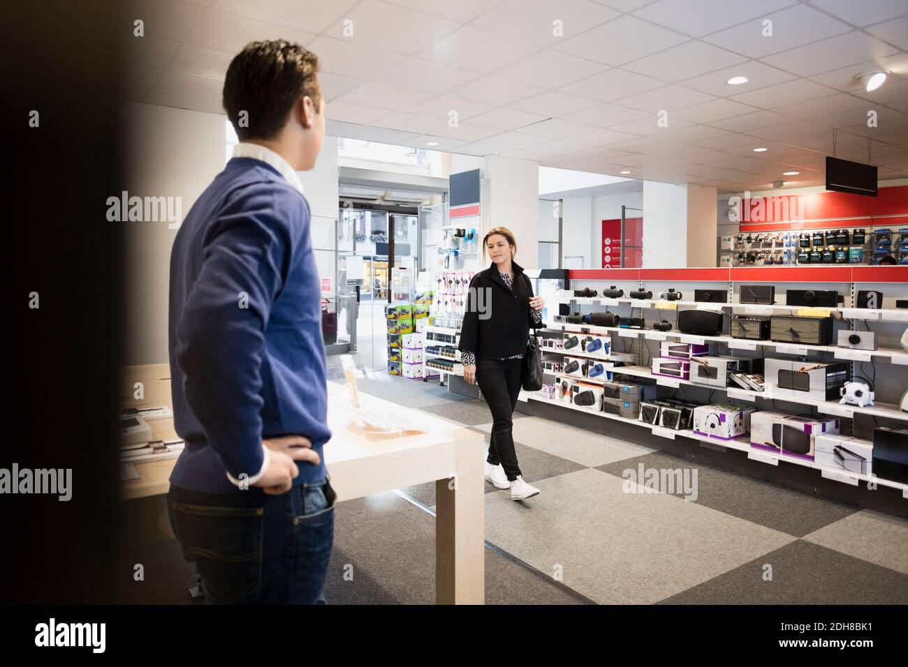 Female customer entering in electronics store Stock Photo - Alamy