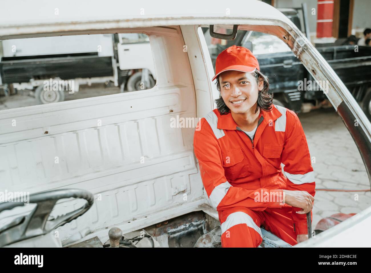portrait of a happy mechanic with the car in his workshop Stock Photo ...