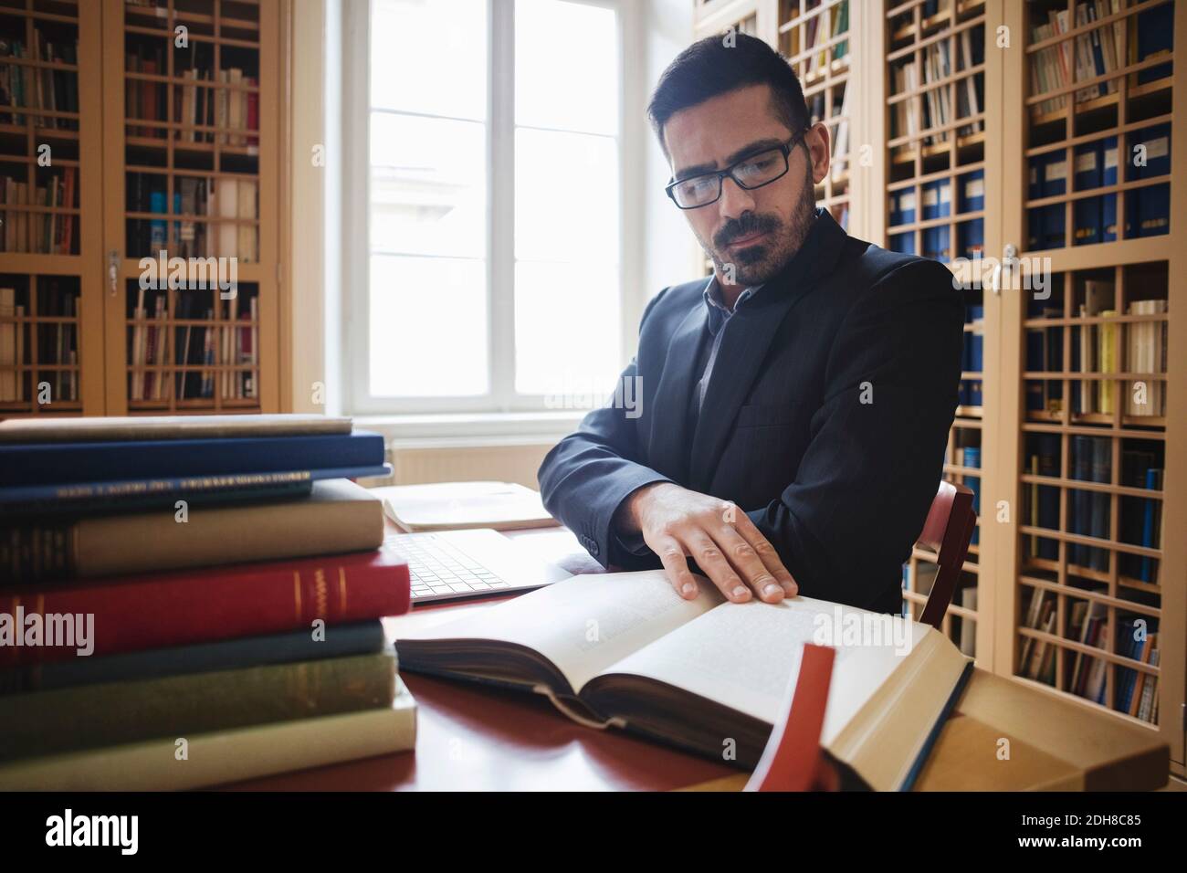 Serious professional reading book while sitting in law library Stock ...