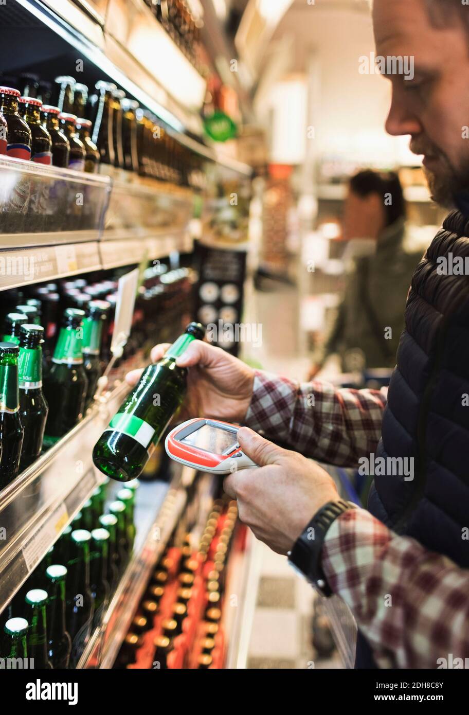 Man using bar code reader on beer bottle in supermarket Stock Photo - Alamy