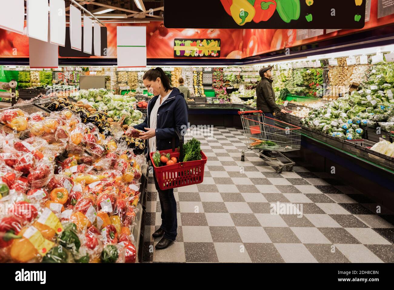 People buying groceries while standing in supermarket Stock Photo - Alamy