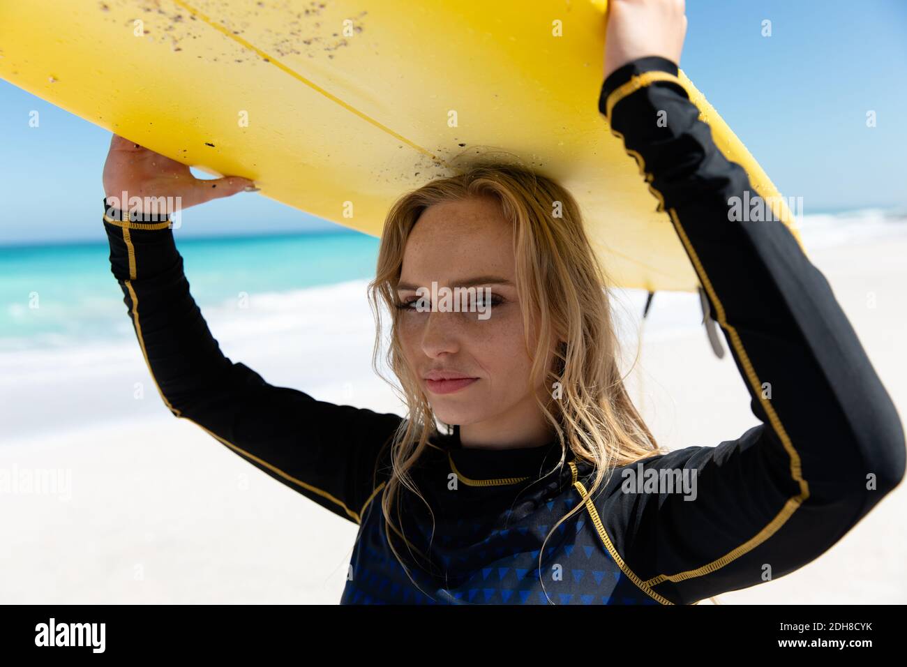 Young woman carrying a surfboard at the beach Stock Photo - Alamy