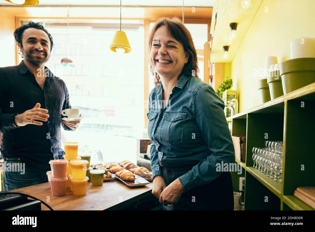 Happy female owner standing with customer in cafe Stock Photo - Alamy