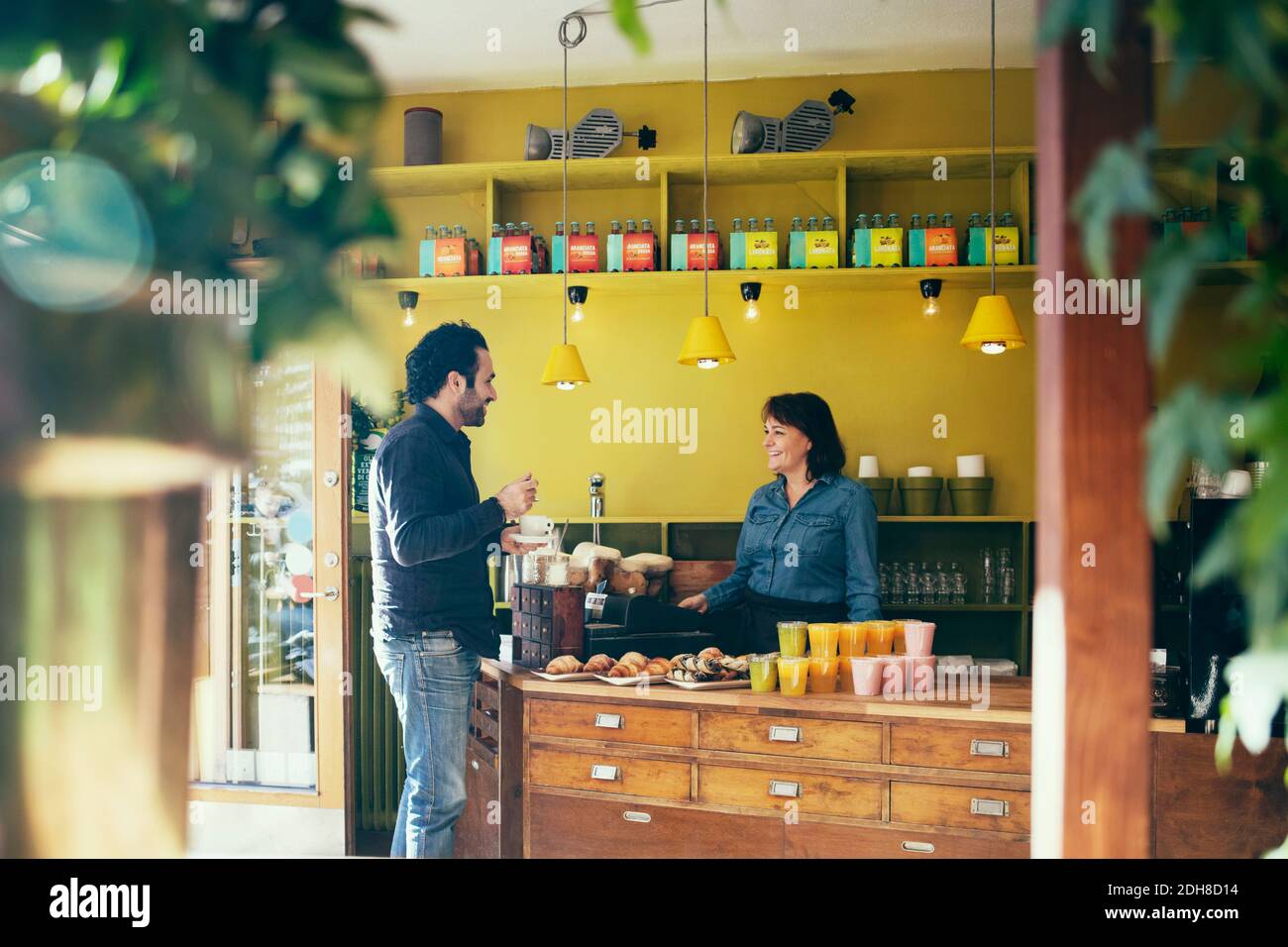 Smiling customer with waitress standing in coffee shop Stock Photo - Alamy