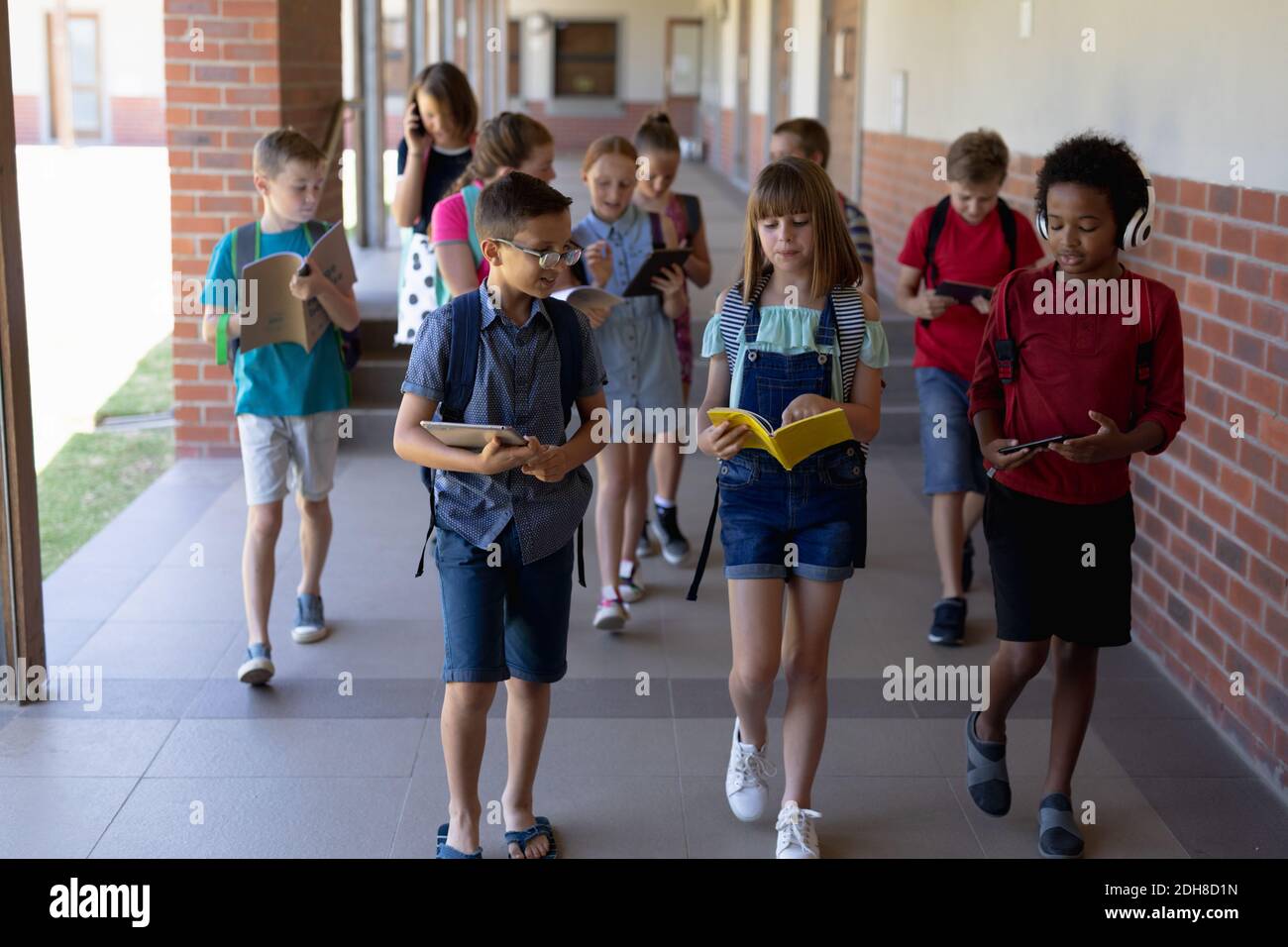 Group of school pupils walking in an outdoor corridor at elementary ...