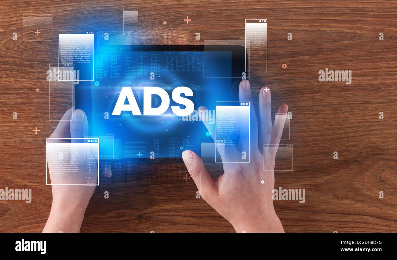 Close-up of a hand holding tablet with ADS abbreviation, modern ...
