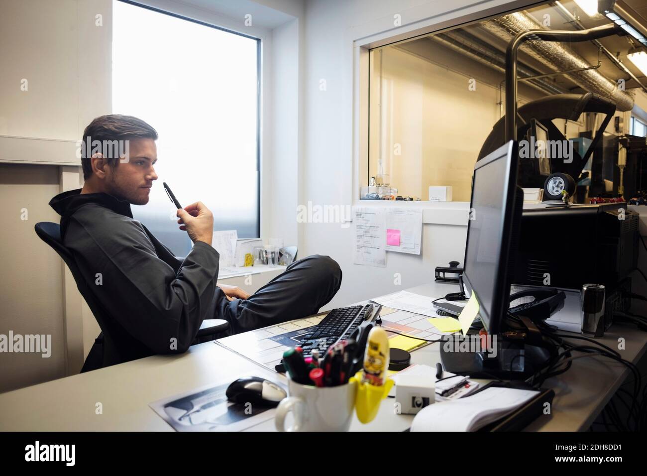 Confident male owner looking at computer monitor in office Stock Photo ...