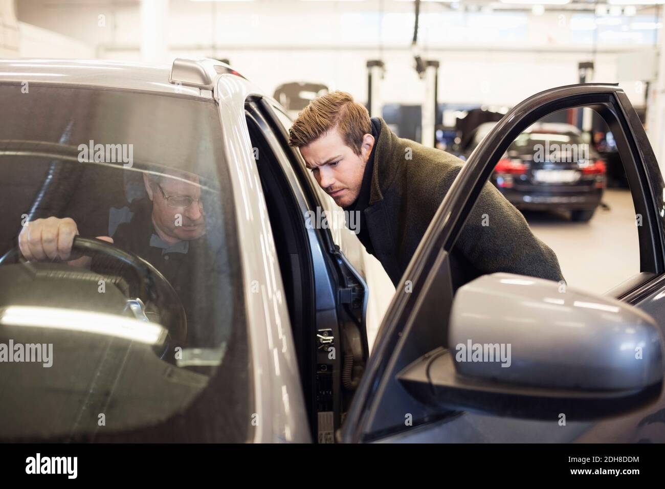 Male customer and mechanic at auto repair shop Stock Photo - Alamy