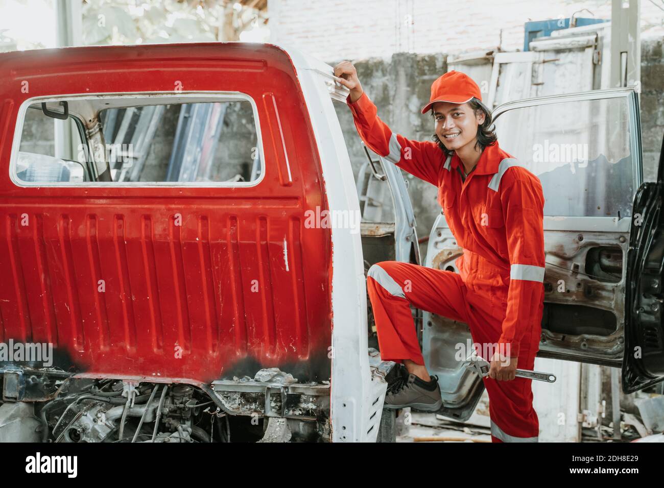 portrait of a young man working as an auto mechanic in a garage Stock ...