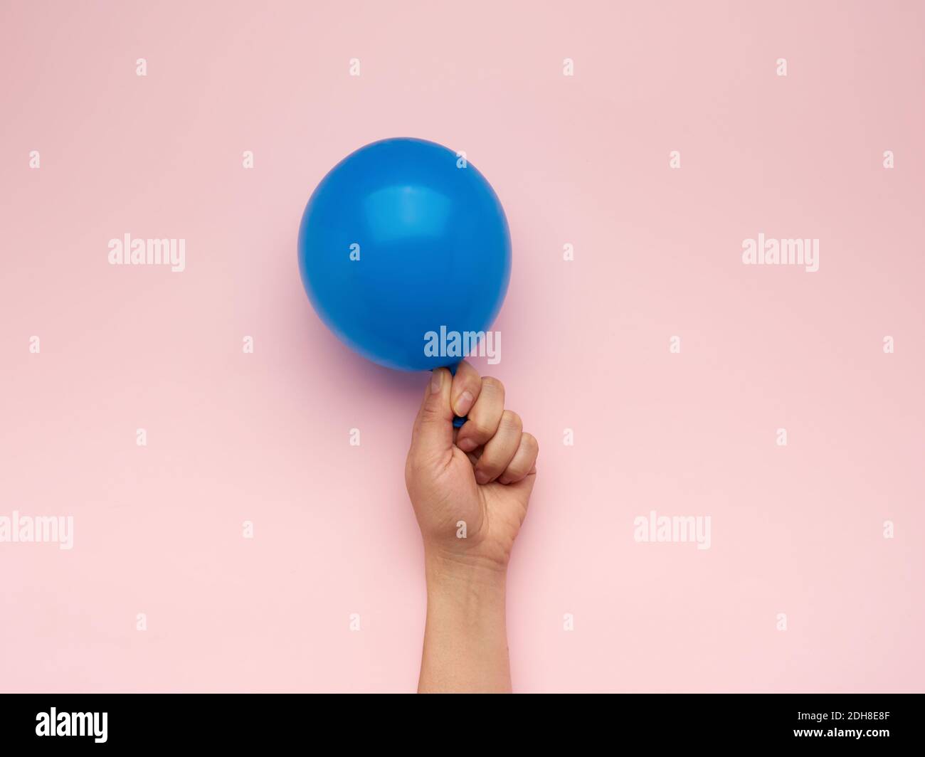 Female hand holding an inflated blue air balloon Stock Photo - Alamy