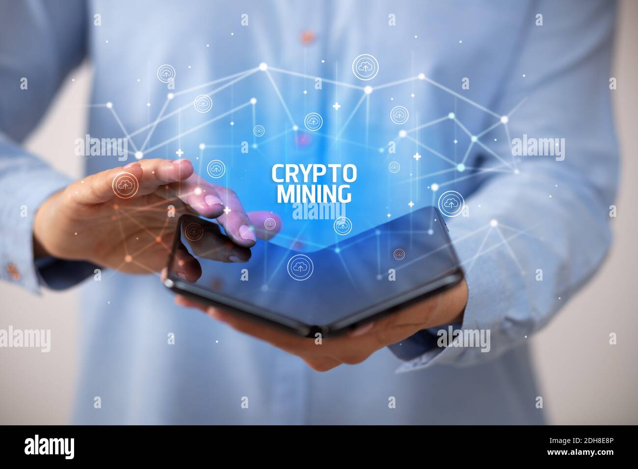 Businessman holding a foldable smartphone with CRYPTO MINING ...