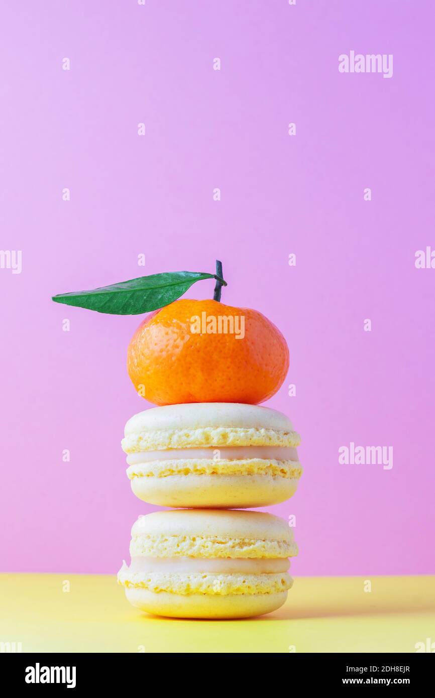 Yellow french macaroon pastries with lemon cream on yellow and pink ...