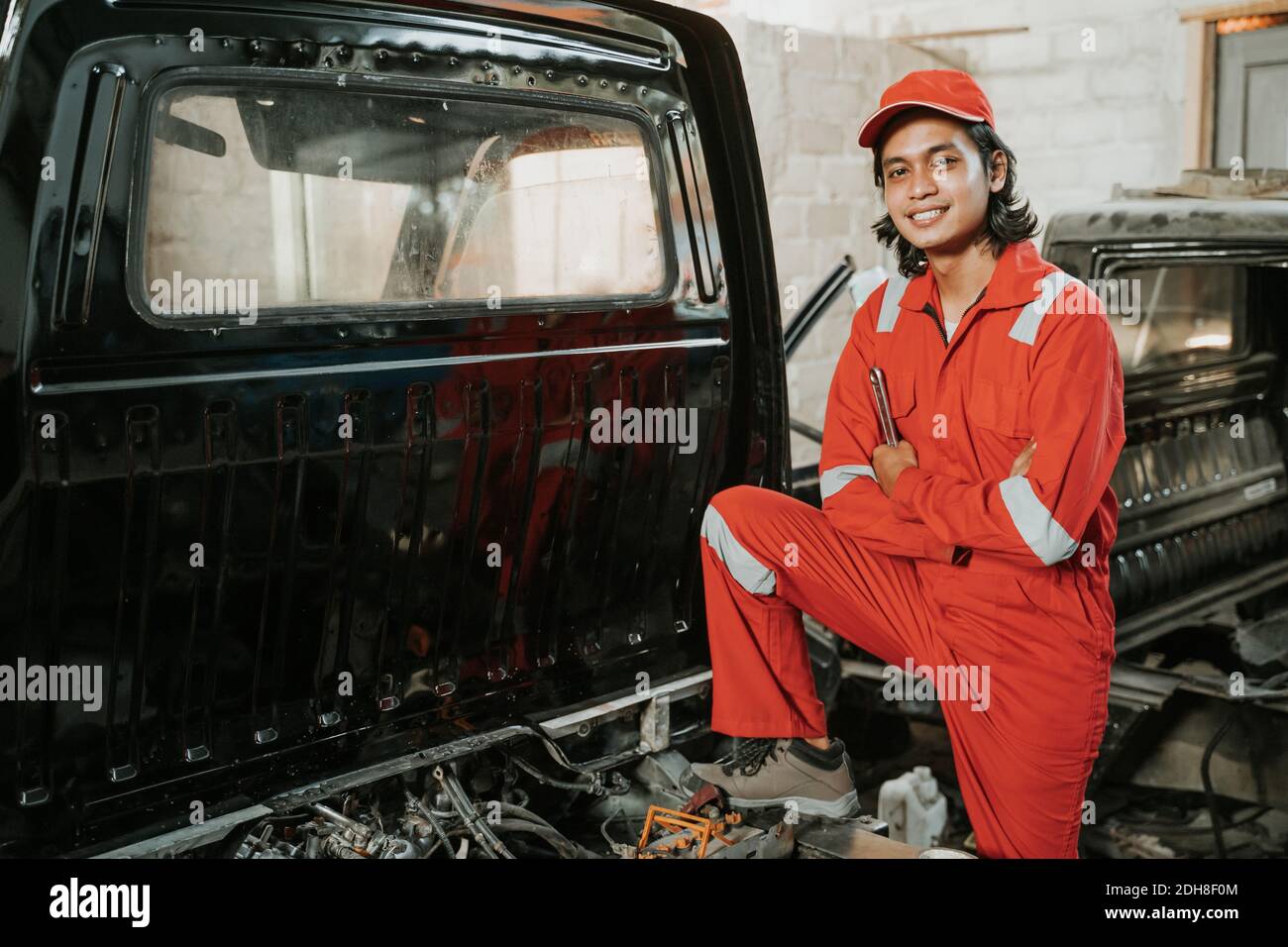 portrait of a young man working as an auto mechanic in a garage Stock ...