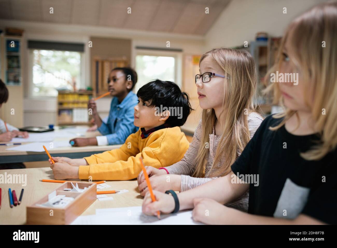 Concentrated students sitting at desk in classroom Stock Photo - Alamy