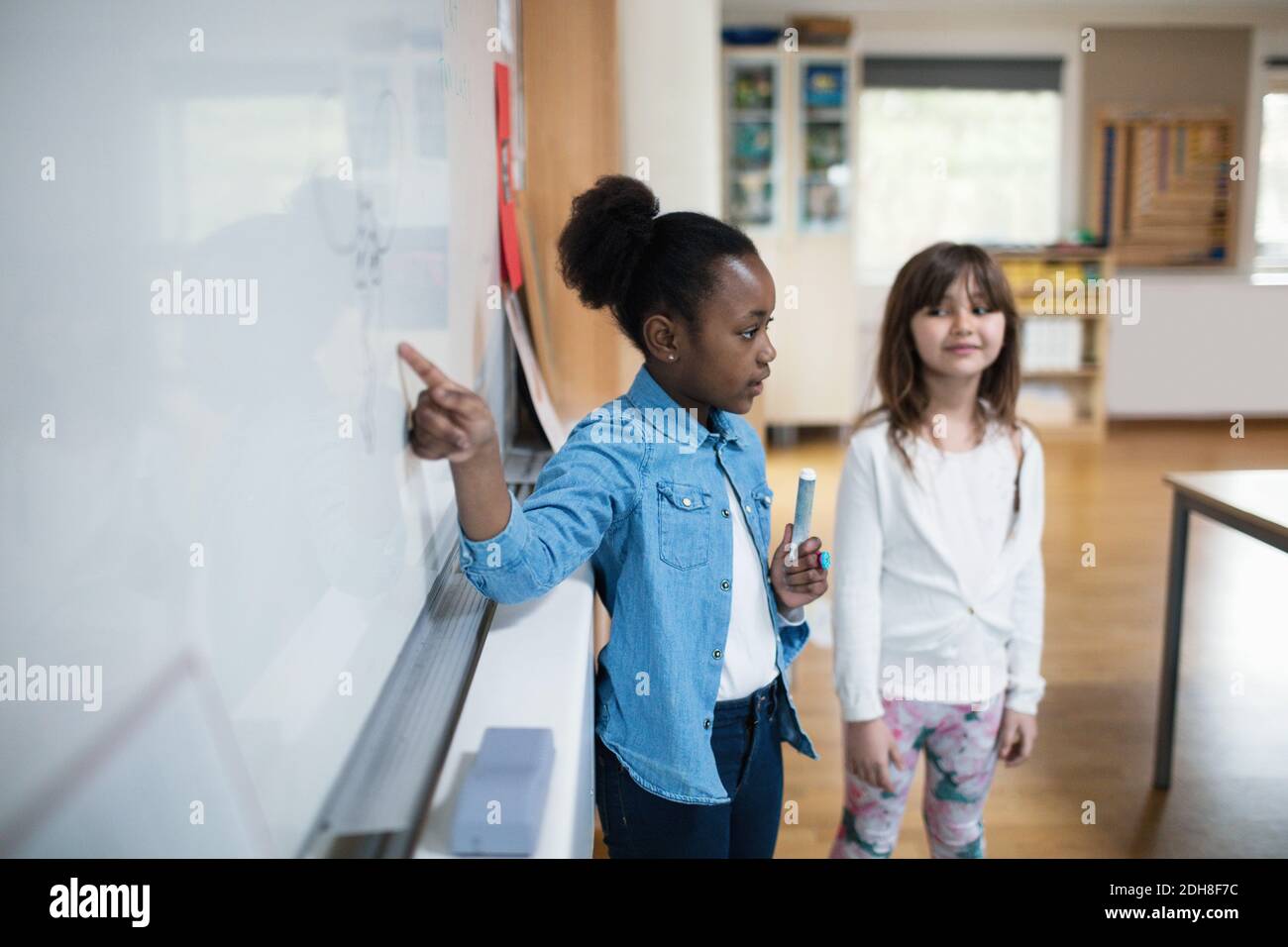 Confident student explaining while standing with classmate against ...