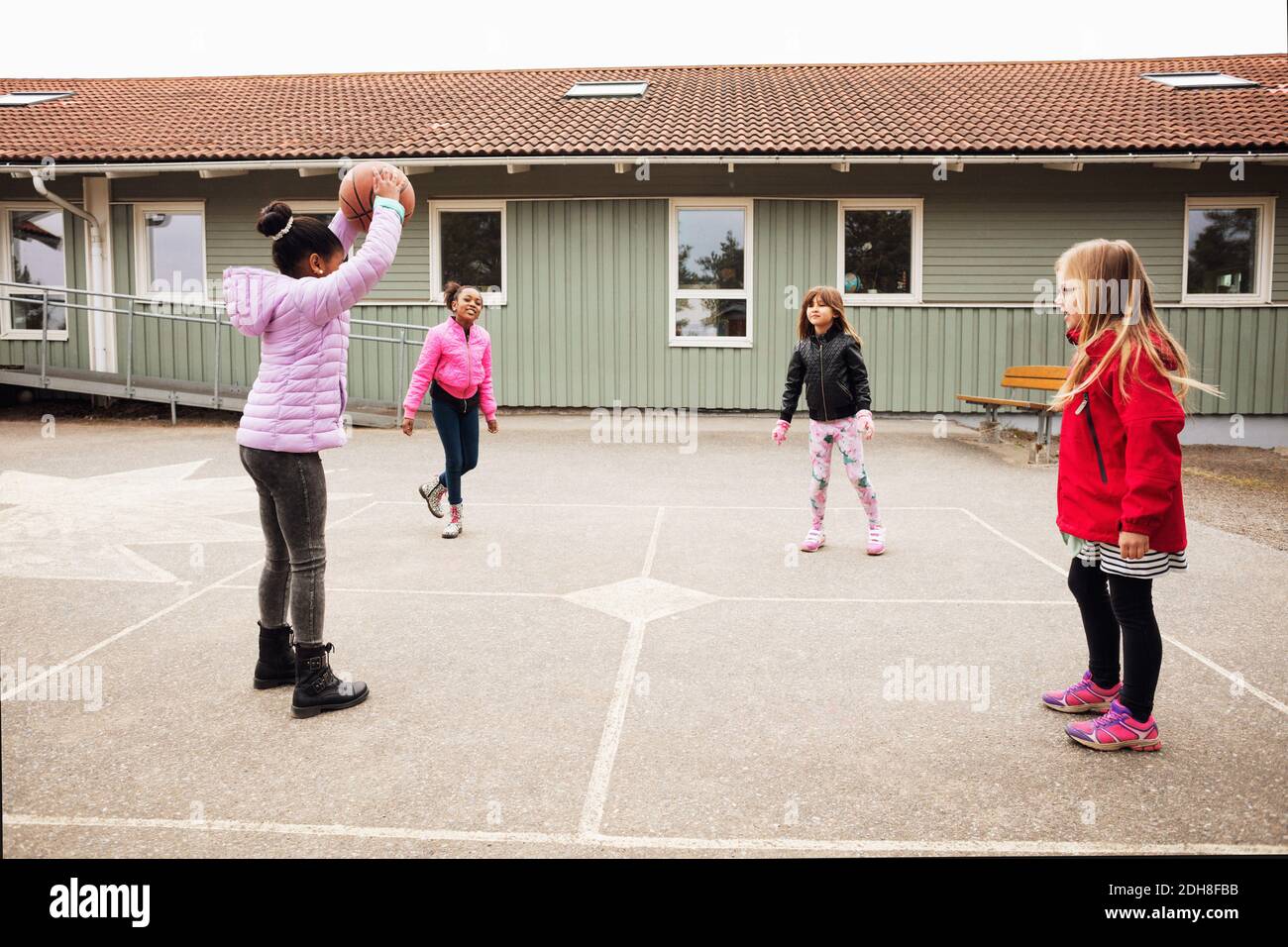 High angle view of children playing with ball in school playground ...