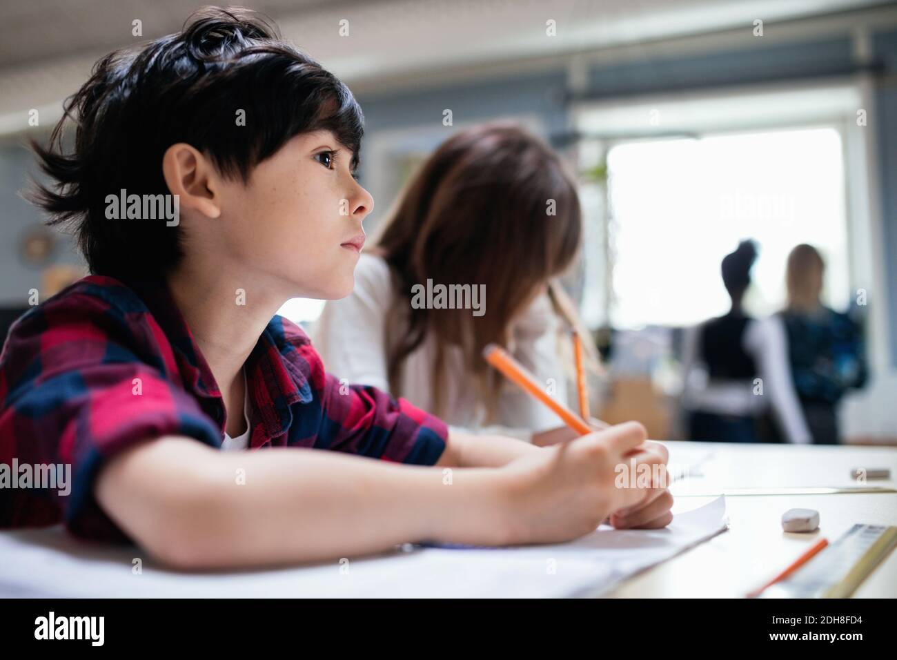 Serious students studying at desk in classroom Stock Photo - Alamy