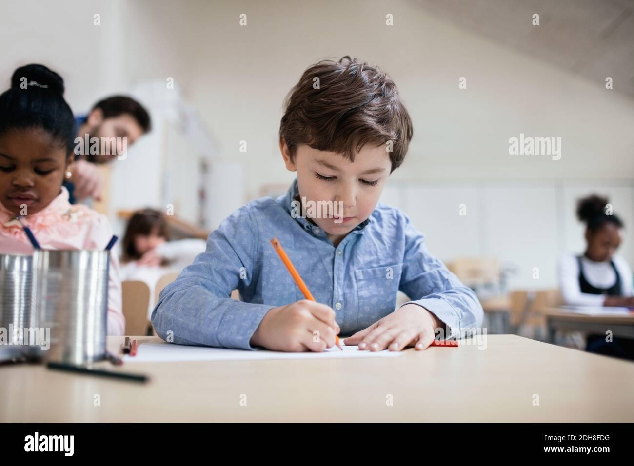 Serious boy studying while sitting in classroom at school Stock Photo ...
