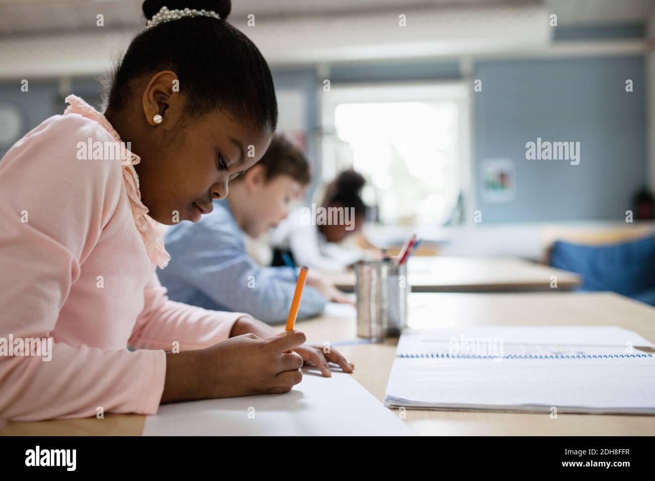 Concentrated students studying at desk in classroom Stock Photo - Alamy