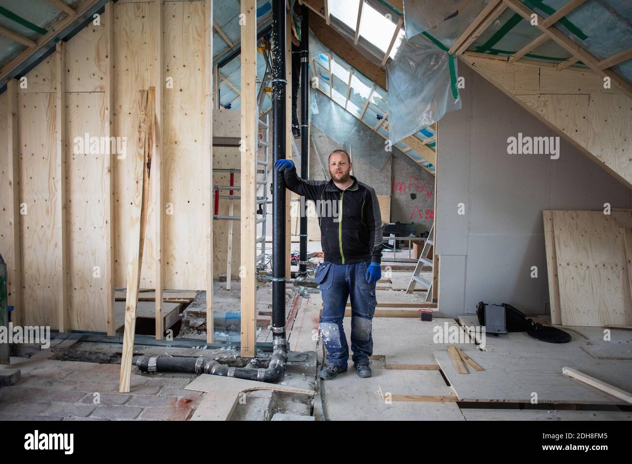 Portrait of confident engineer leaning by pipe at construction site ...