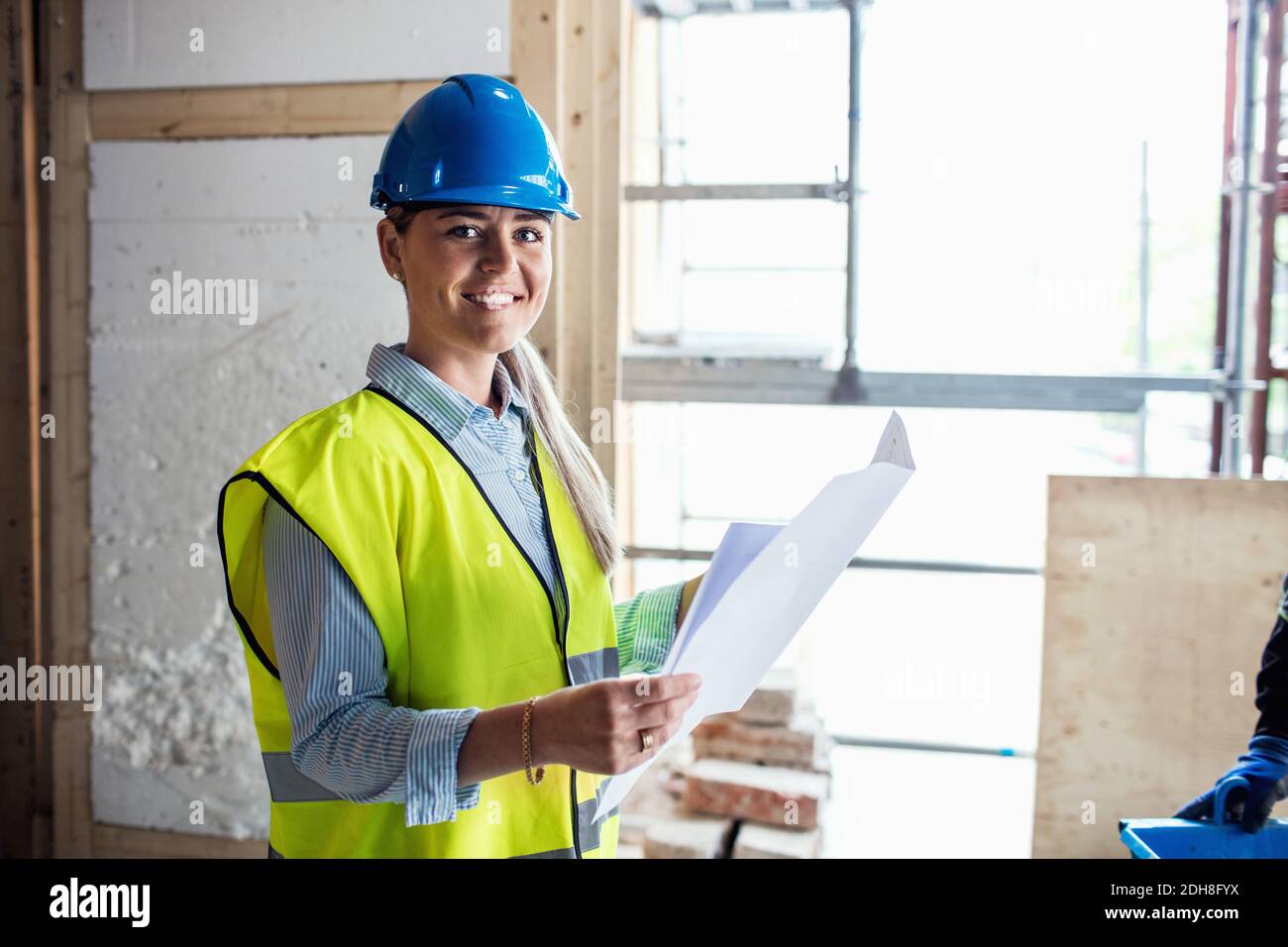 Portrait of confident female manual worker reading document at ...