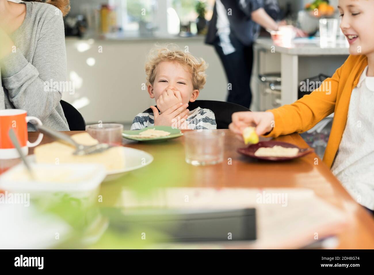 Happy family eating breakfast at home Stock Photo - Alamy