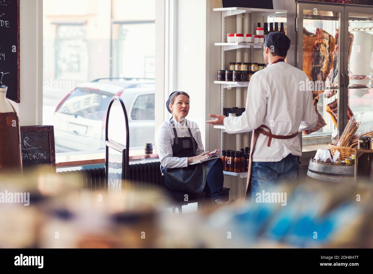 Male and female colleagues discussing in grocery store Stock Photo - Alamy