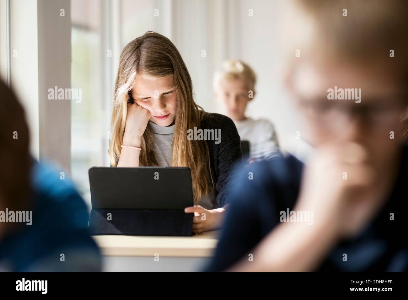 Girl reading from digital tablet for learning in classroom Stock Photo ...