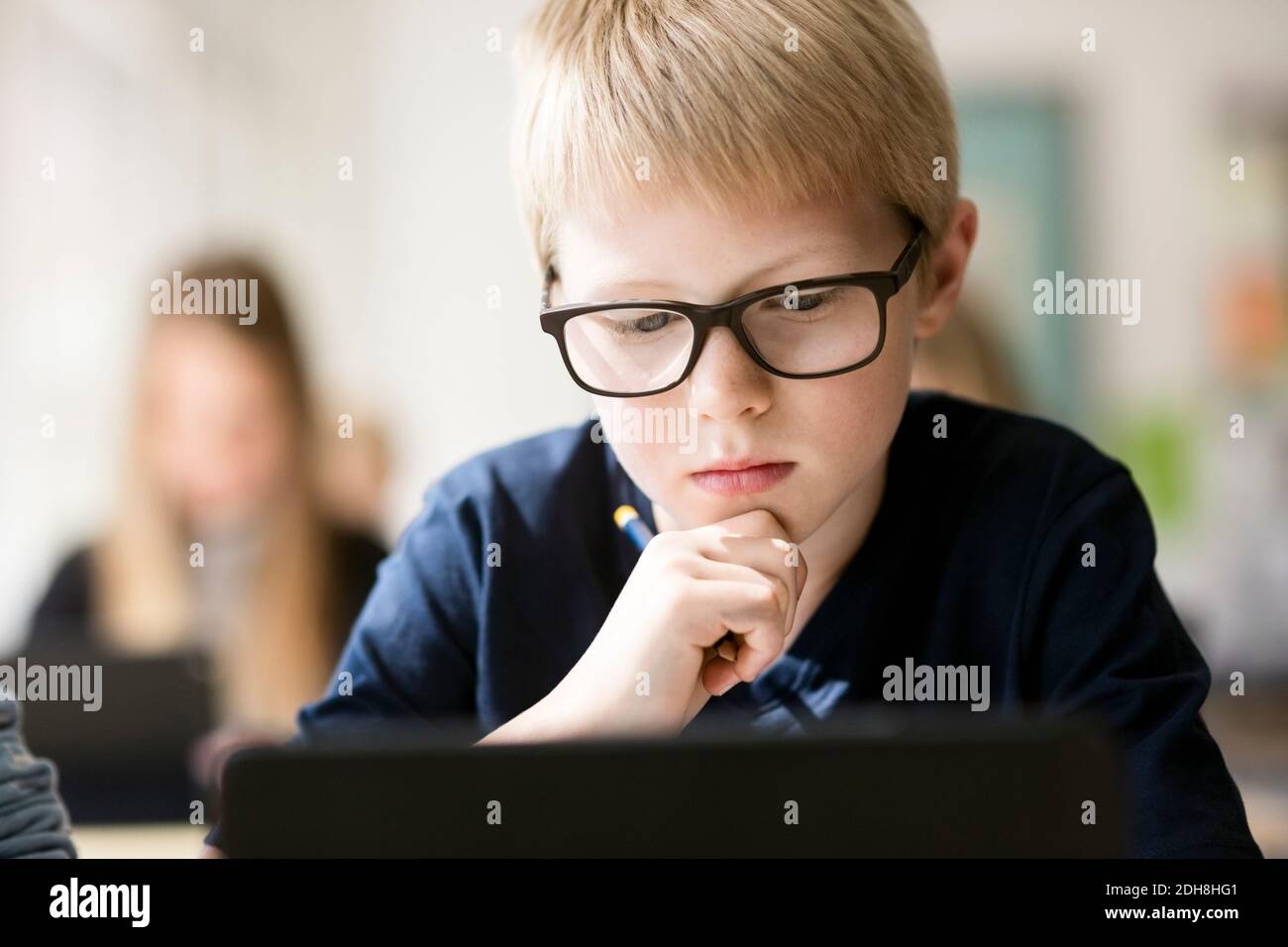 Boy concentrating on learning in classroom Stock Photo - Alamy