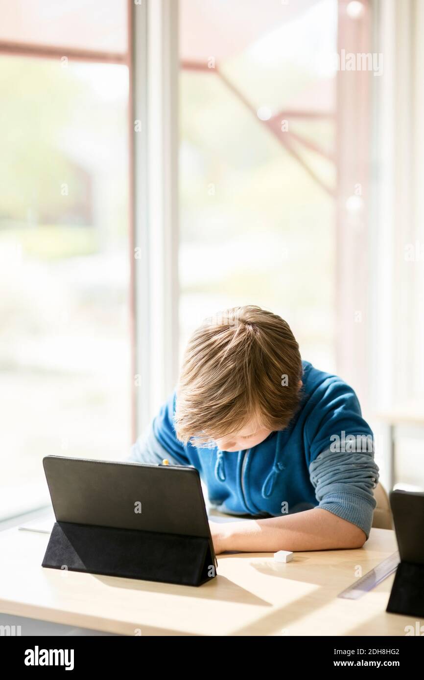 Boy using digital tablet for learning in classroom Stock Photo - Alamy