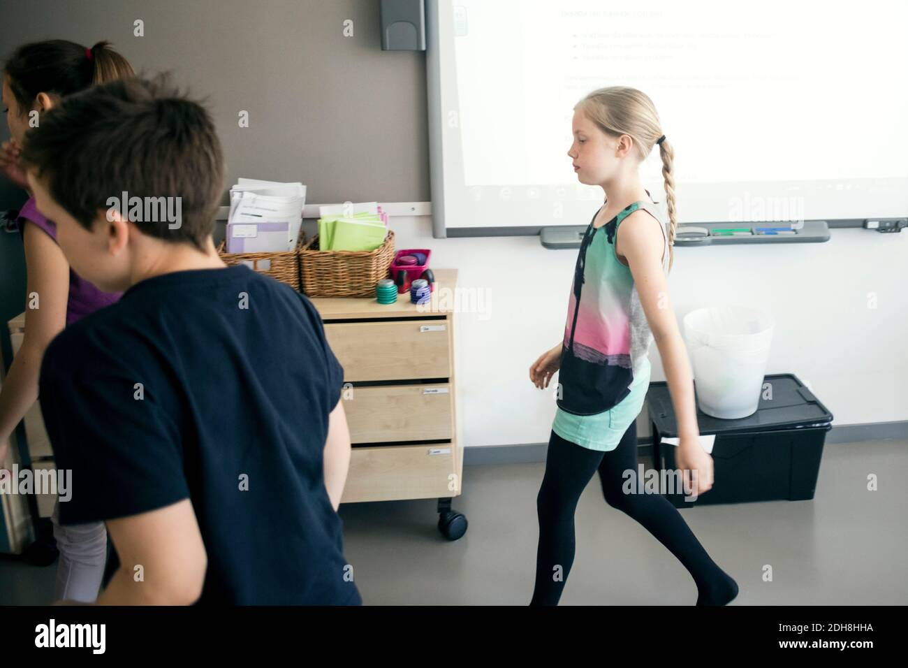 School children walking against whiteboard in classroom Stock Photo - Alamy