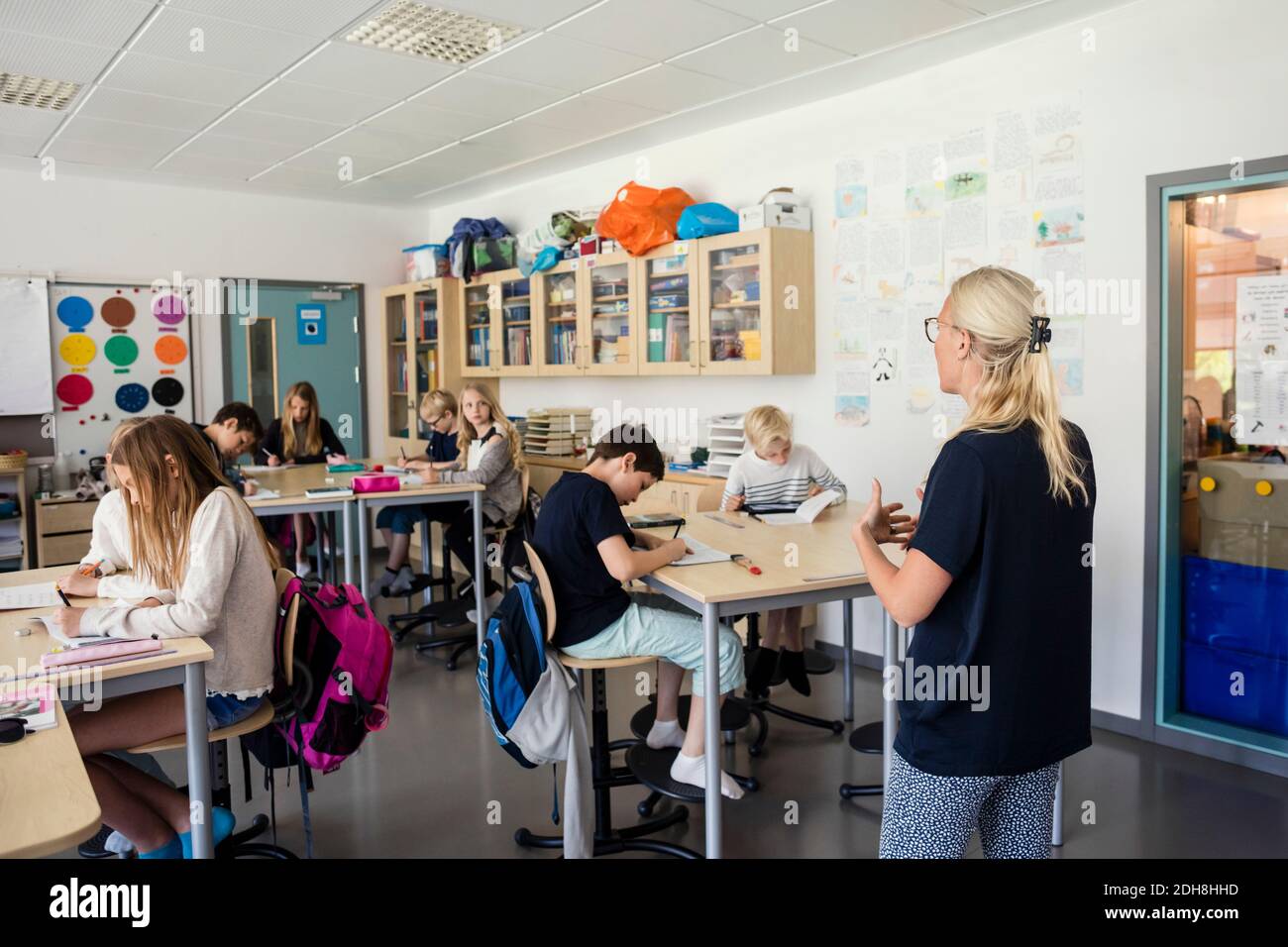 Teacher explaining students in classroom Stock Photo - Alamy