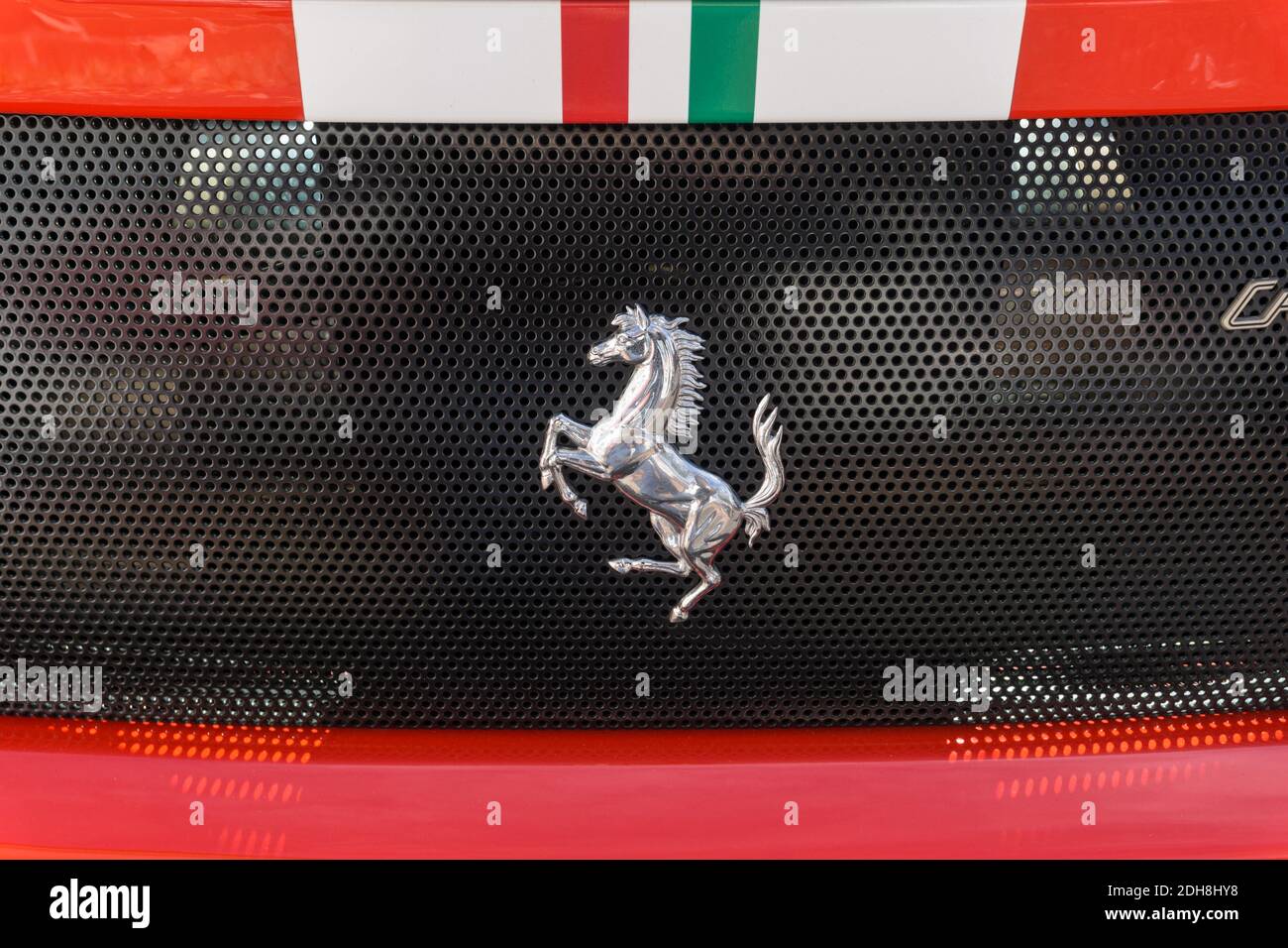 Close up detail of the rear grille and emblem badge on a red rosso ...
