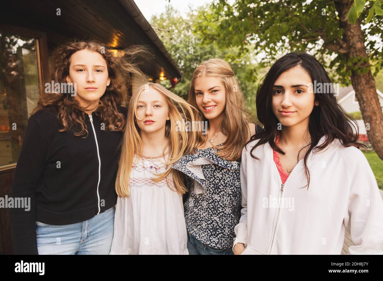 Portrait of happy teenage girls standing at yard Stock Photo - Alamy