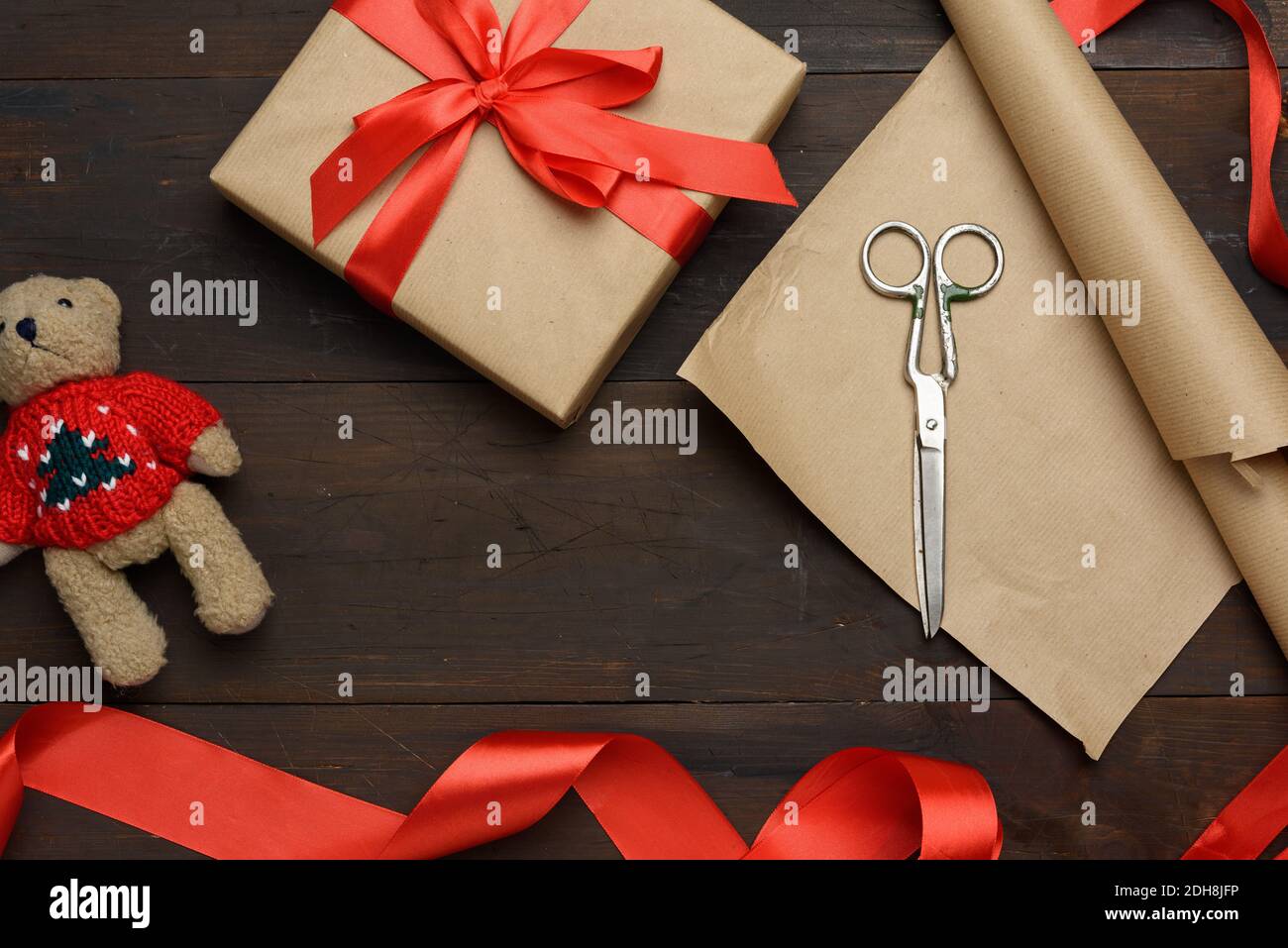 roll of brown kraft packaging paper, box tied with a red silk ribbon ...