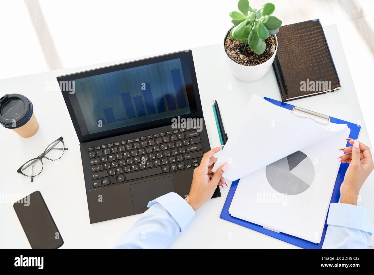 Top view of businesswoman analyzing financial reports sitting on modern ...