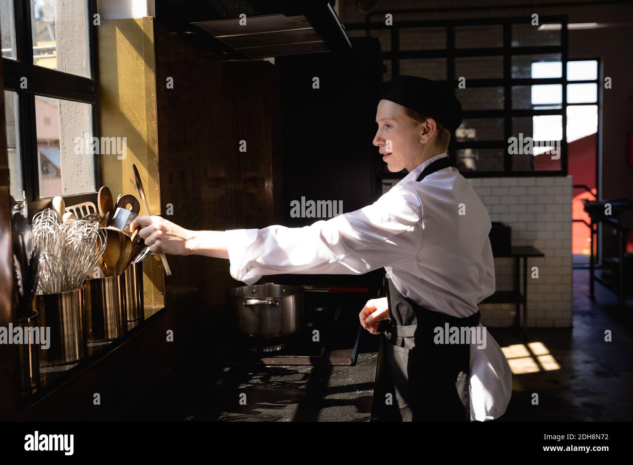 Caucasian chef taking some kitchen equipment Stock Photo - Alamy