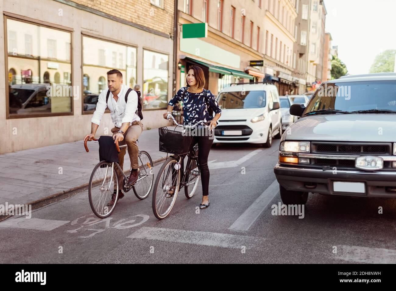 Business people riding bicycle on city street Stock Photo - Alamy