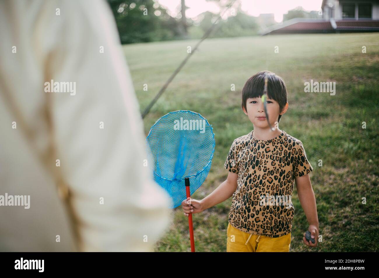 Portrait of girl with fishing net standing in backyard Stock Photo - Alamy