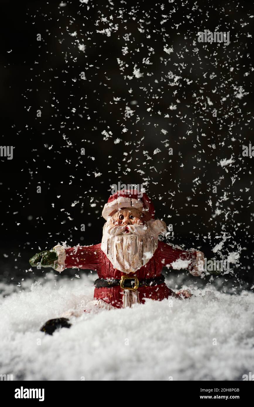 a santa claus sitting on the snow while is snowing Stock Photo - Alamy