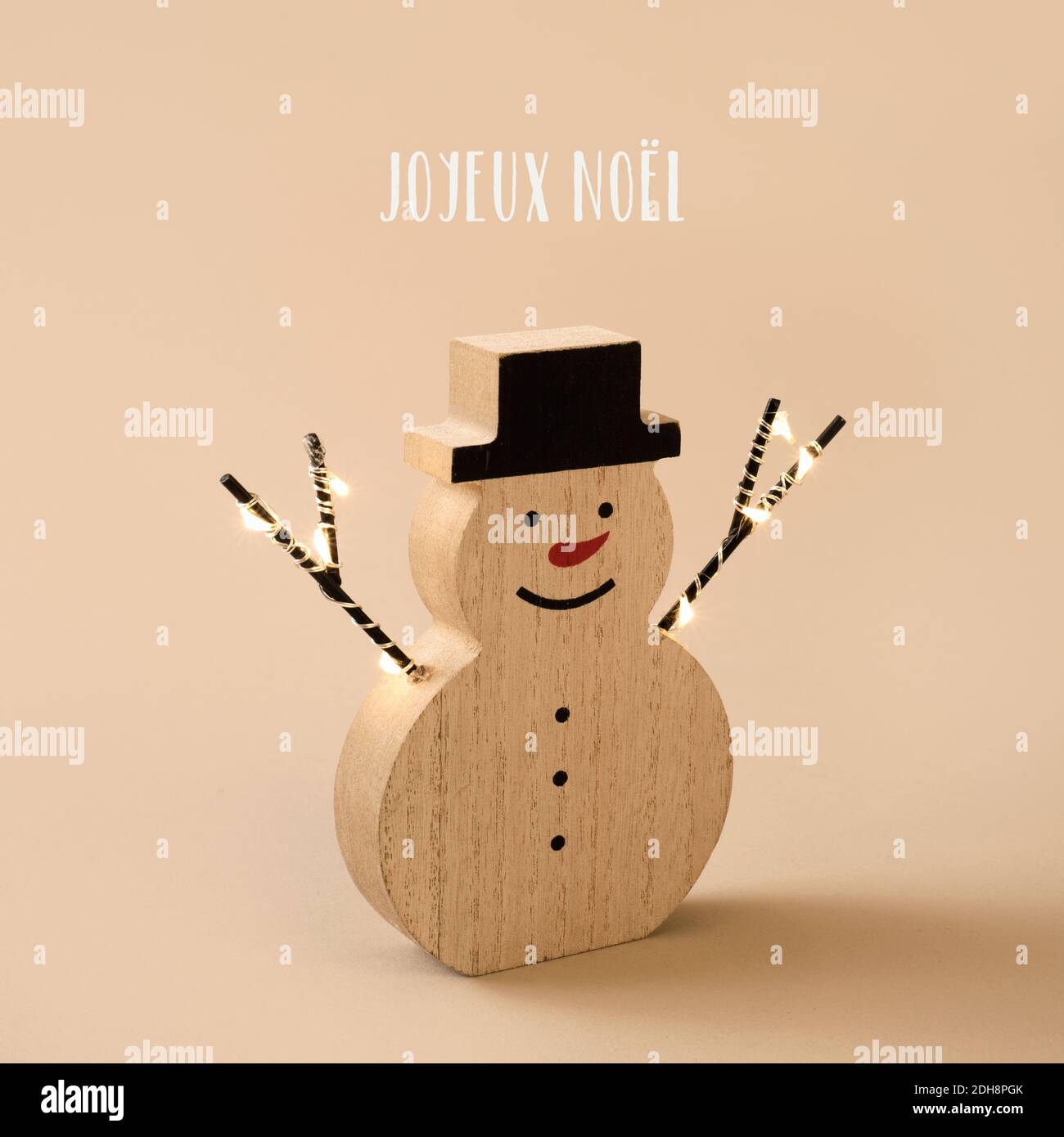 a funny wooden snowman, with a red nose and wearing a hat, and the text ...