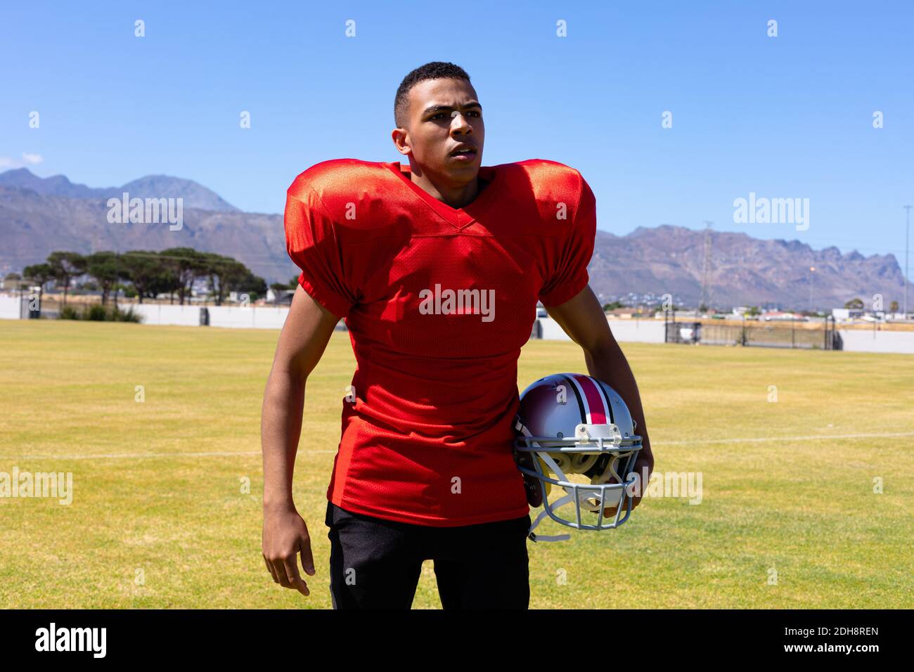 Football player carrying his helmet Stock Photo - Alamy