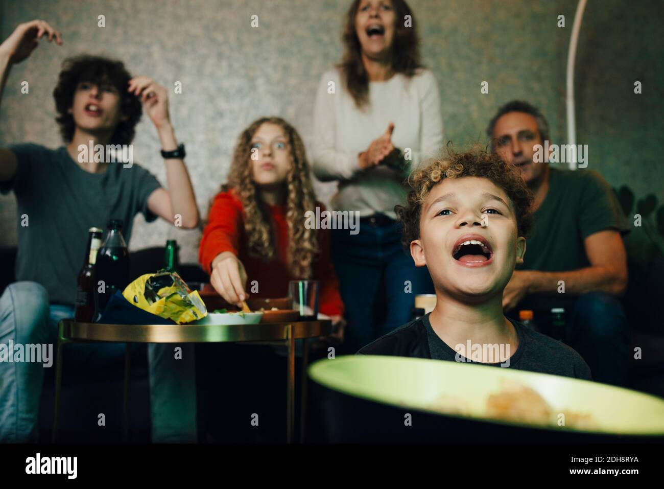 Boy shouting while family cheering during sporting event at night Stock ...