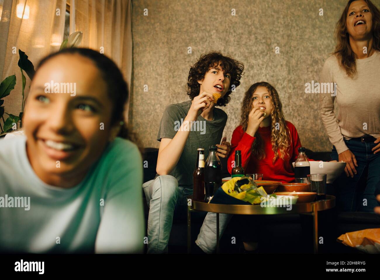 Male and female siblings watching sports together at night Stock Photo ...